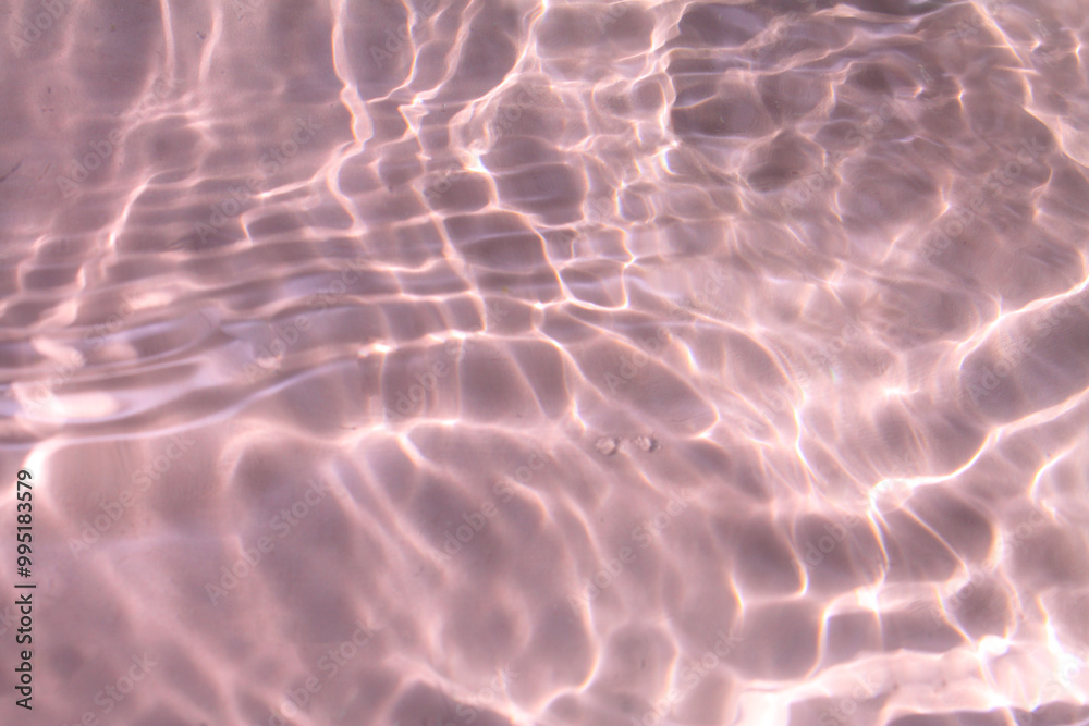 Pink water bubbles on the surface ripples. Defocus blurred transparent ...