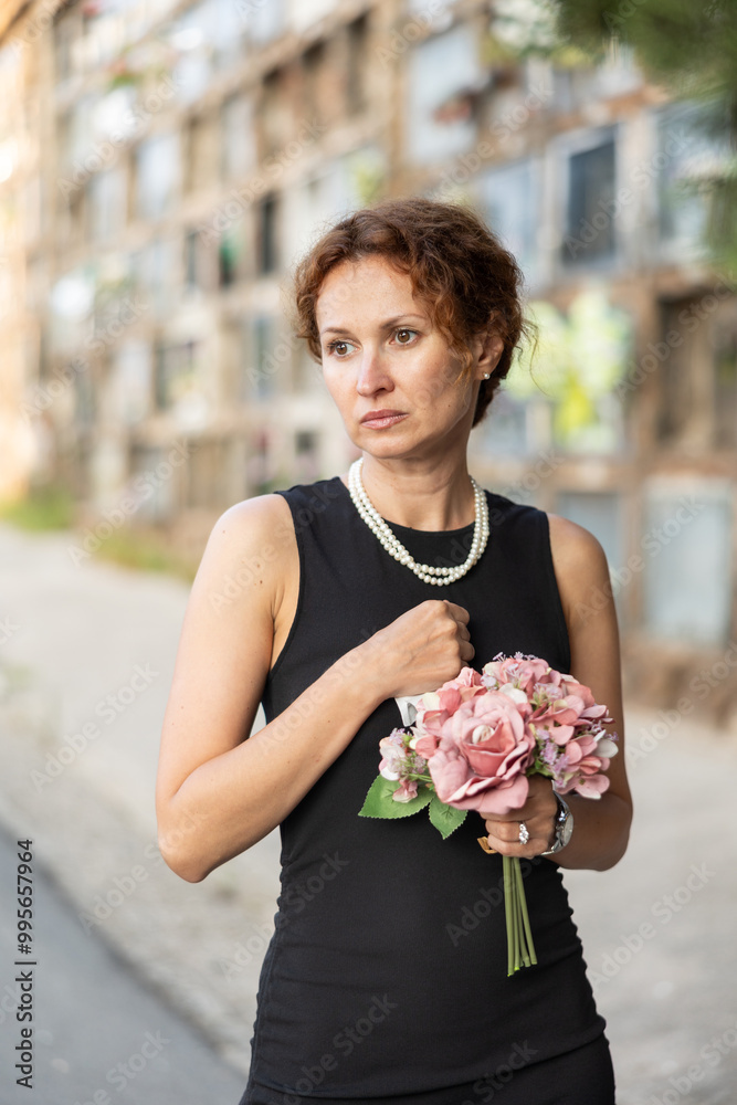 Sad woman in black mourning dress and pearl necklace standing in front ...