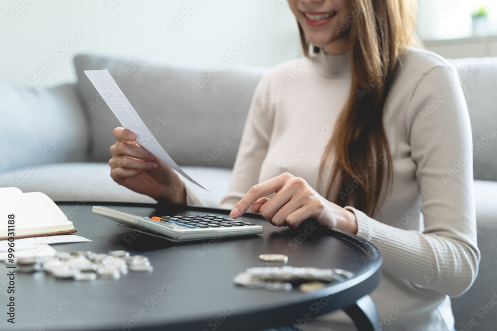 young woman looking at credit card invoice checking receipt before pay ...
