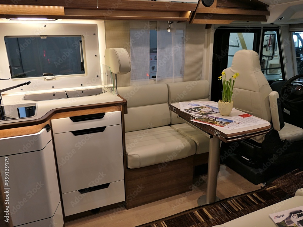 Part of kitchen corner and dining table placed alongside rear seats in ...