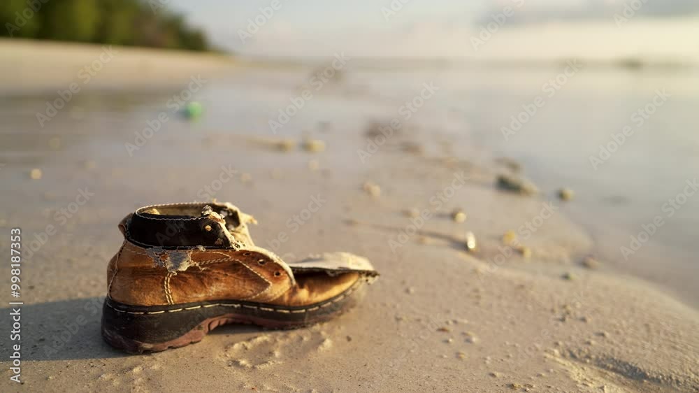 Discarded footwear on a sandy beach highlighting shoe waste impact on ...