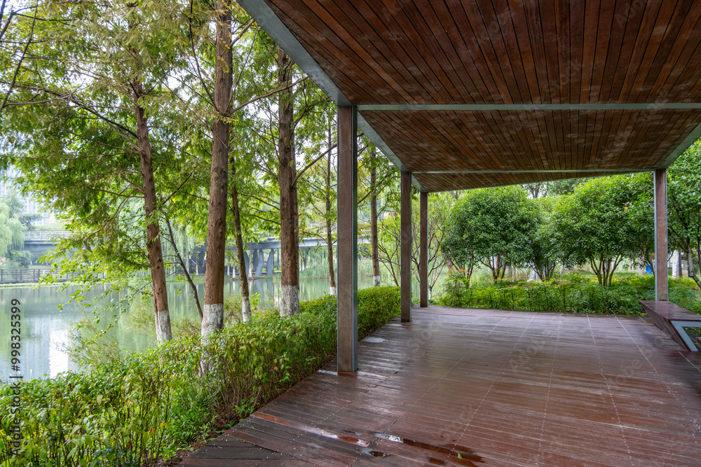 A peaceful wooden terrace, surrounded by trees and shrubs, overlooks a ...