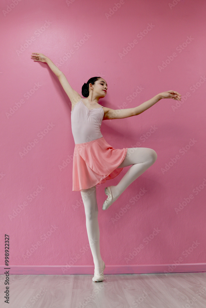 Beautiful teenage ballerina girl practicing ballet dance on pink ...