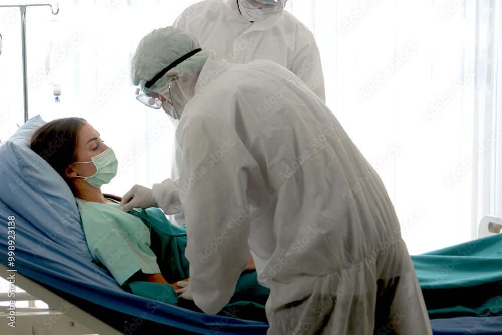 Infected female patient with face mask lying in bed at disease ...