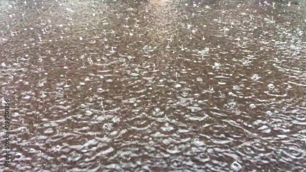 4k heavy rain drops falling into puddles on asphalt. Raindrop falling ...