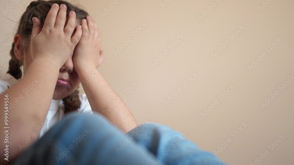 sad girl sitting in the corner crying a covered her face with her hands ...