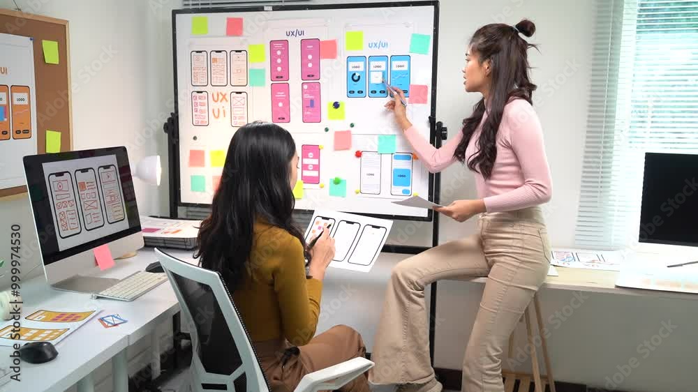 Two Asian Women Designers Are Discussing A Ux Ui Design For A Mobile Application Using A