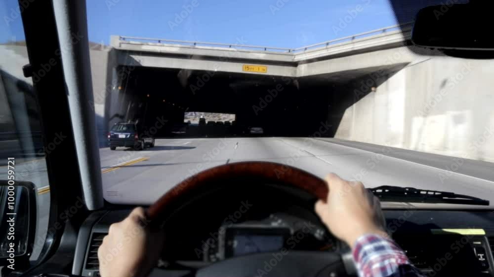 Point of view from inside a car driving on a highway towards a tunnel ...