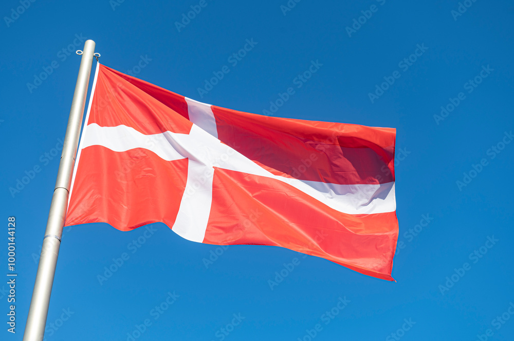Flag of Denmark flying in the wind with a blue sky background...country ...