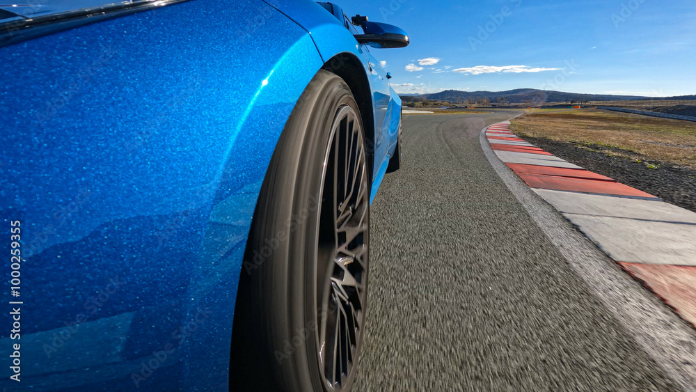 LOW ANGLE, CLOSE UP: Metallic blue sports car racing on a closed ...