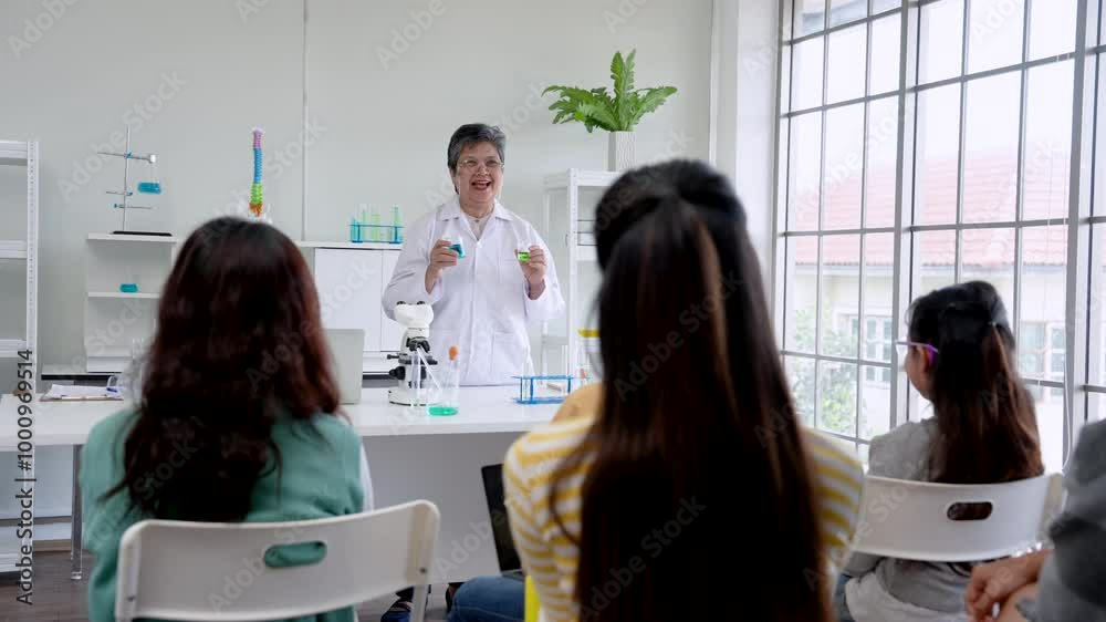 Elderly teacher teaches science course, holding laboratory flask in ...