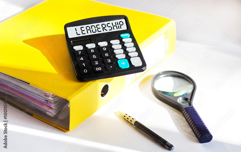 Calculator showing leadership word, folder, magnifying glass and pen on ...