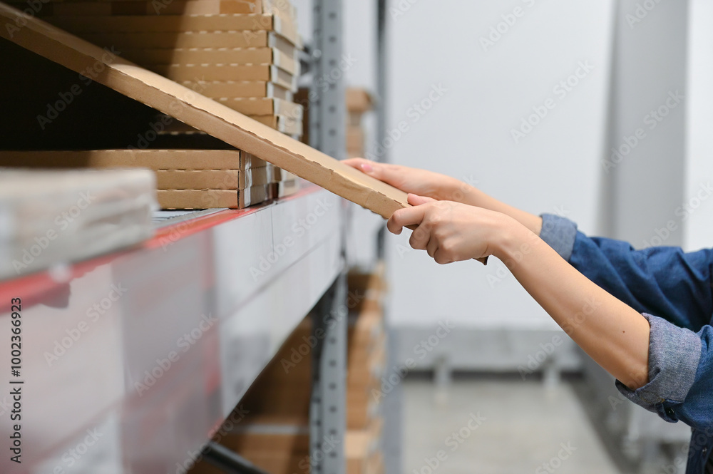 Hands placing a large cardboard box onto a shelf, focusing on proper ...