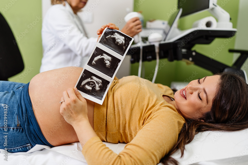 Beautiful and pregnant woman is happy after pregnancy medical check up ...