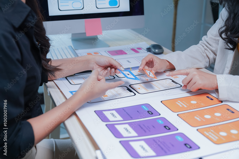 Web designers collaborating on mobile app layout, brainstorming ideas ...