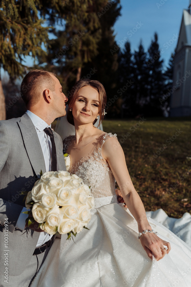 A bride and groom are posing for a picture in front of a church. The ...