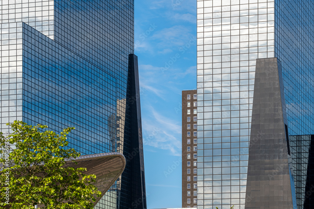 Two reflective glass skyscrapers stand tall, divided by a gap, under a ...