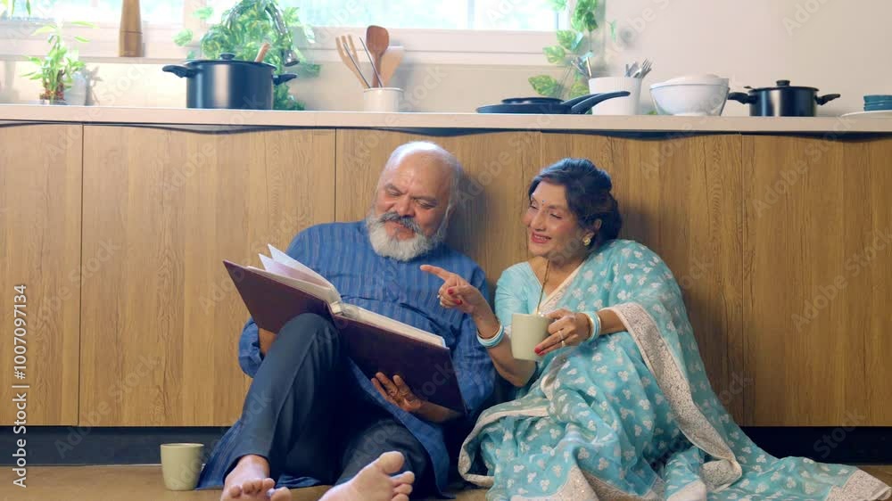 Joyful Indian Asian senior couple sitting comfortably on the kitchen ...