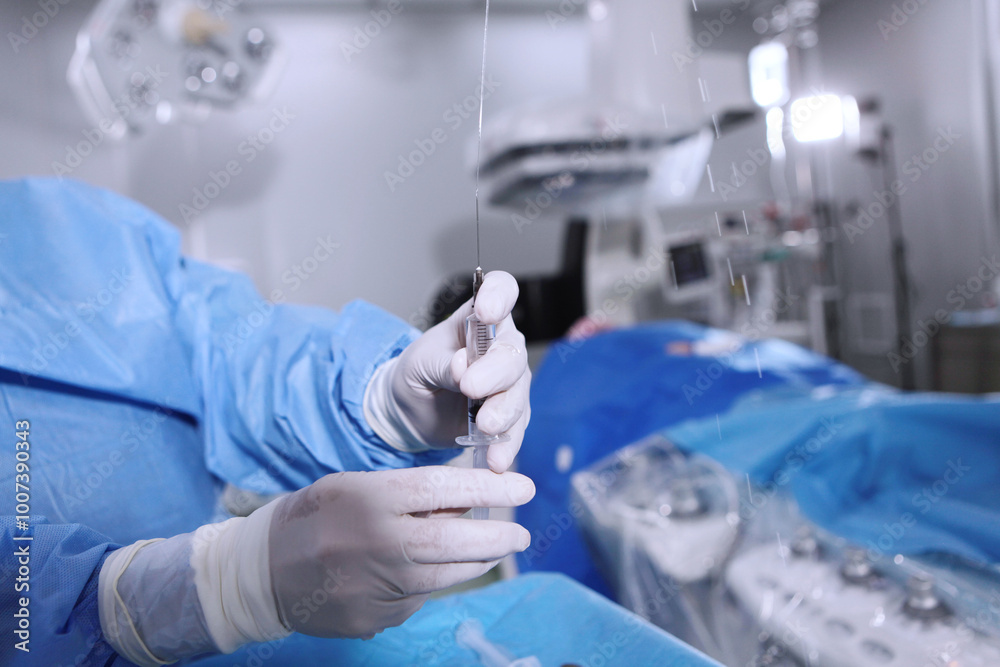 An injection syringe in the hands of a surgical assistant. Surgical ...