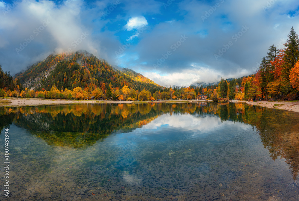 Mountain lake reflecting colorful trees with red and orange foliage at ...