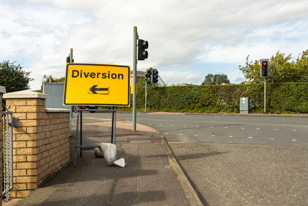 Yellow diversion sign with arrow pointing left on metal frame at road ...