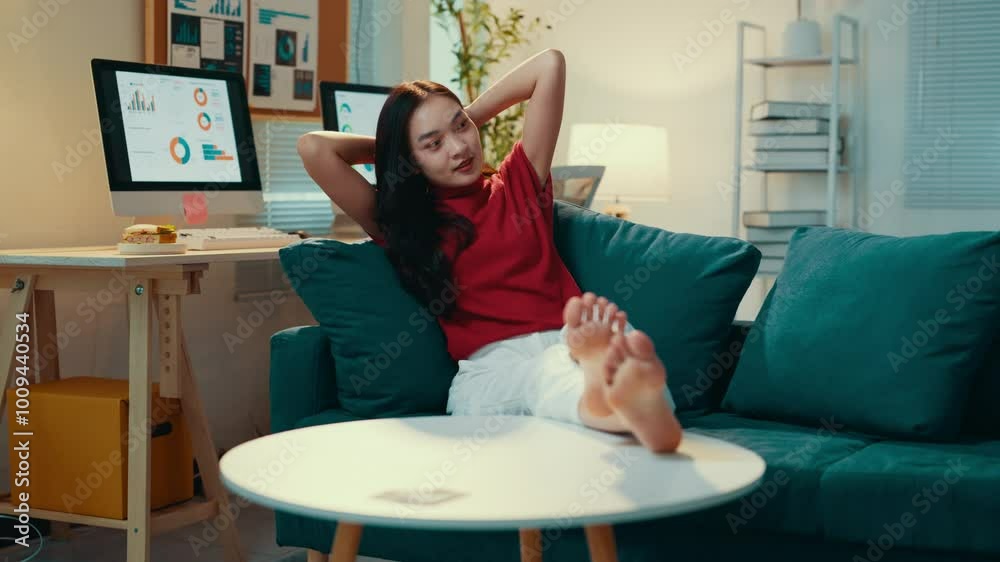 Young woman enjoys a moment of relaxation on her couch after a long day ...