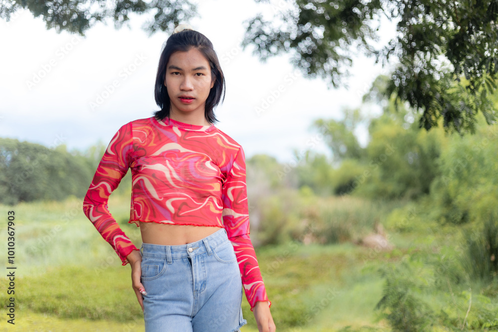 beautiful Asian trans woman in a red top and blue jeans poses in a ...