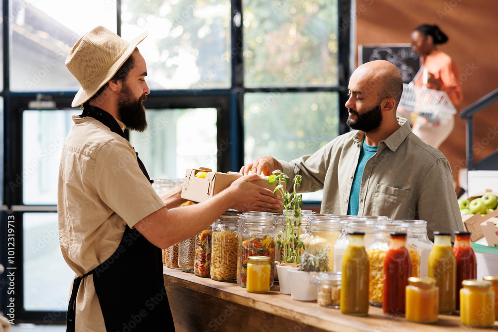 Caucasian male vendor showing freshly harvested box of fruits to the ...