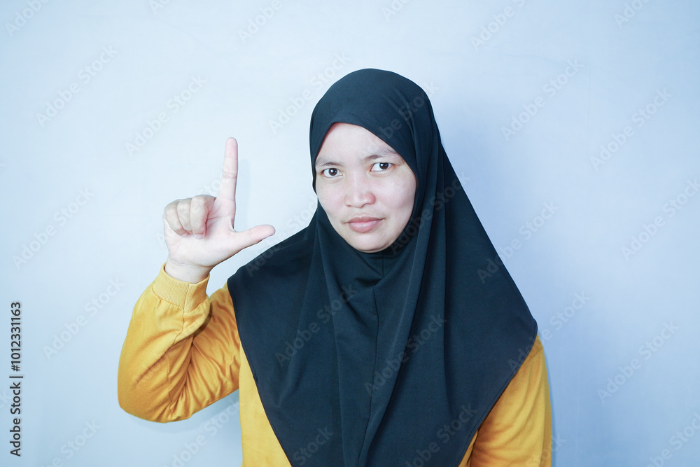Asian muslim woman in yellow dress pointing up with style. asian muslim ...
