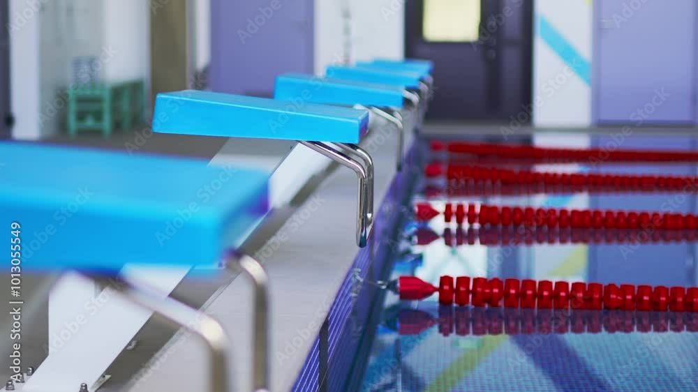 Plastic starting blocks placed along edge of public swimming pool ...