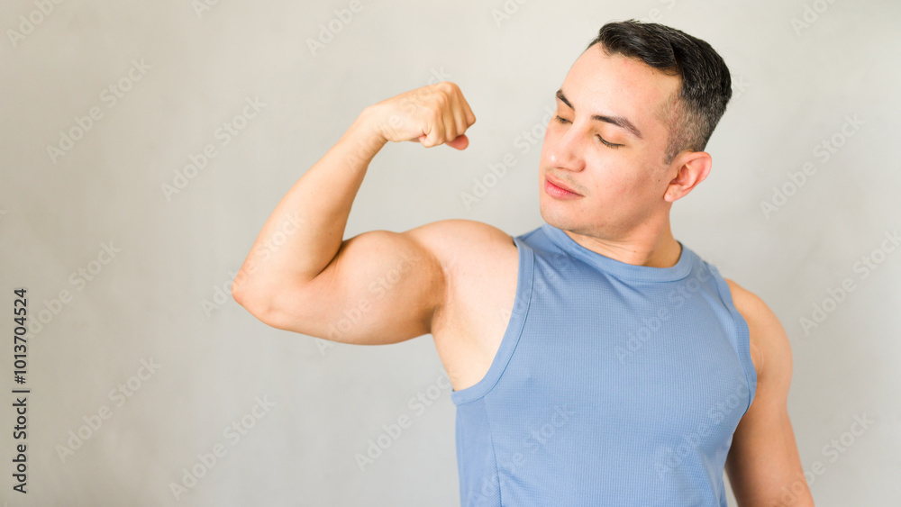 Foto de Strong man checking his muscle progress after a tough workout ...