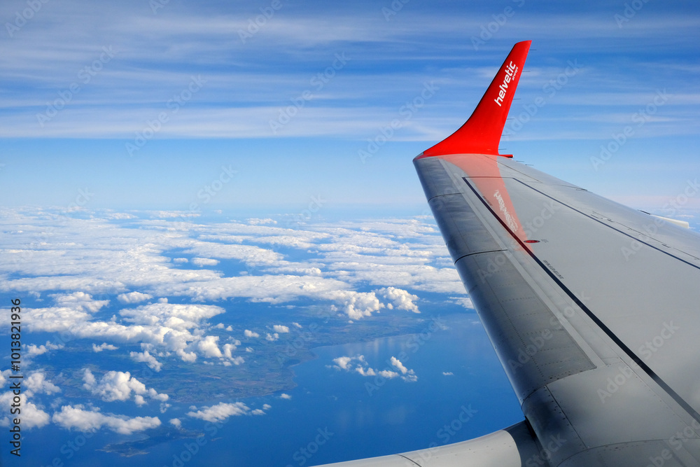 Helvetic Airways Embraer E196 E1 wing in flight, clouds and coast Stock ...