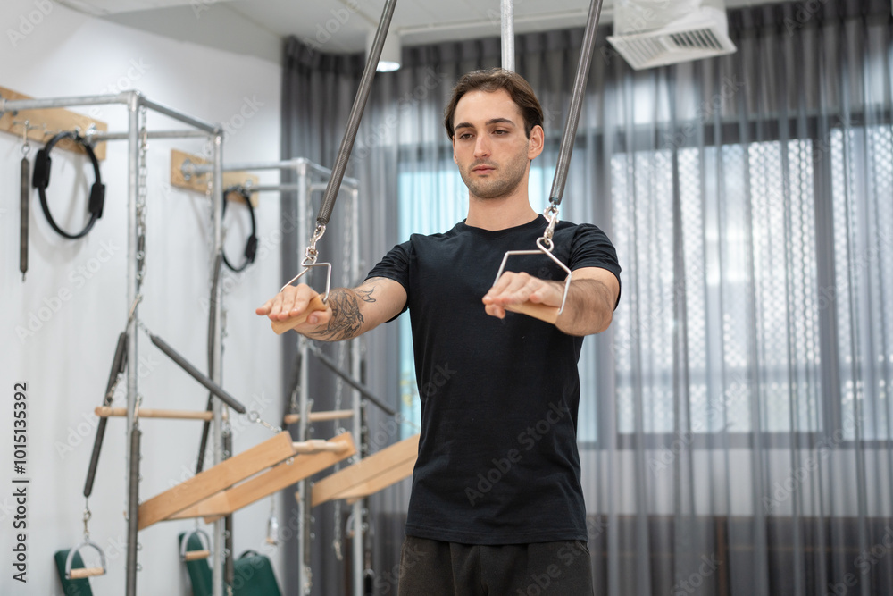 Caucasian men training pilates using reformers during class in fitness ...