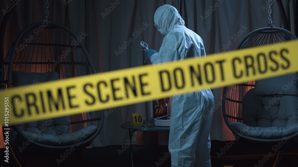 Police tape at a crime scene with a forensic expert working in the ...