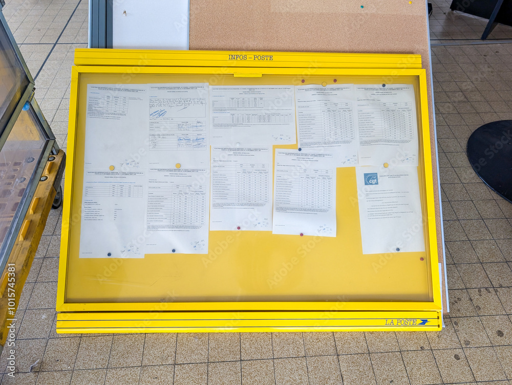 France, 13 July 2024 : Yellow bulletin board displaying various notices ...