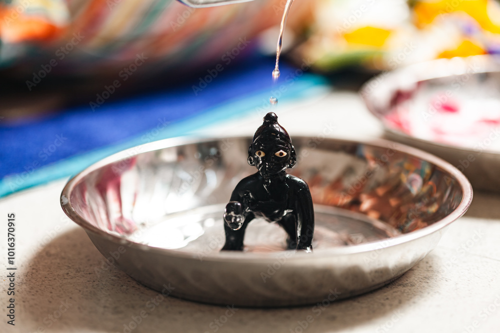 Indian woman performing snan ritual by pouring 'Ganga Jal' on (Laddu ...