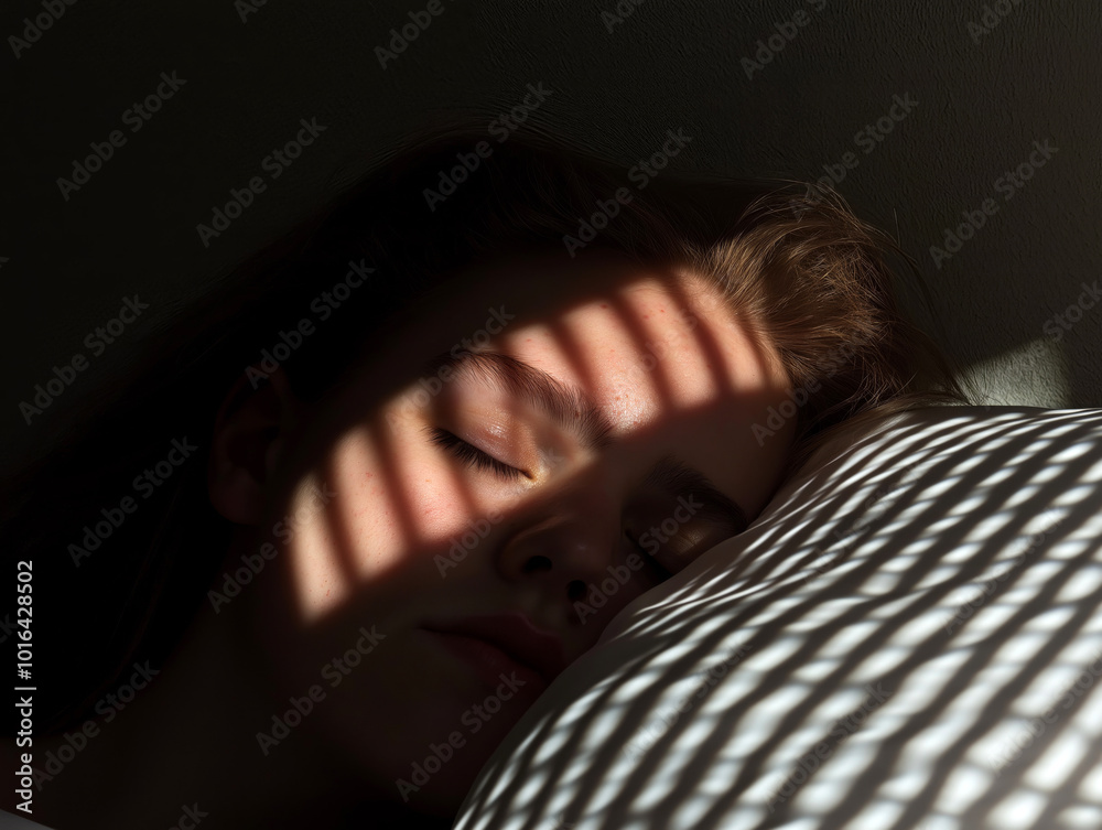 Artistic shadows cast on a sleeping woman’s face, creating a pattern of ...