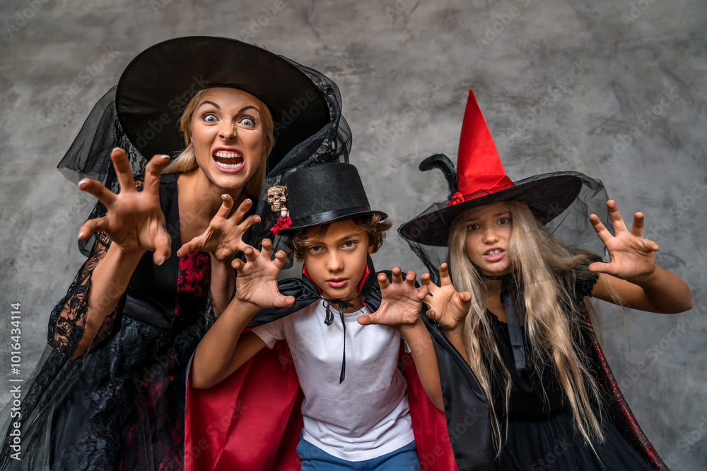 Happy family having fun scaring with look in camera standing over grey ...