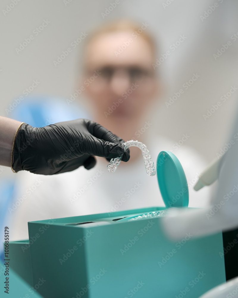 Dentist pulls teeth aligners from box. Demonstration to patient of pre ...