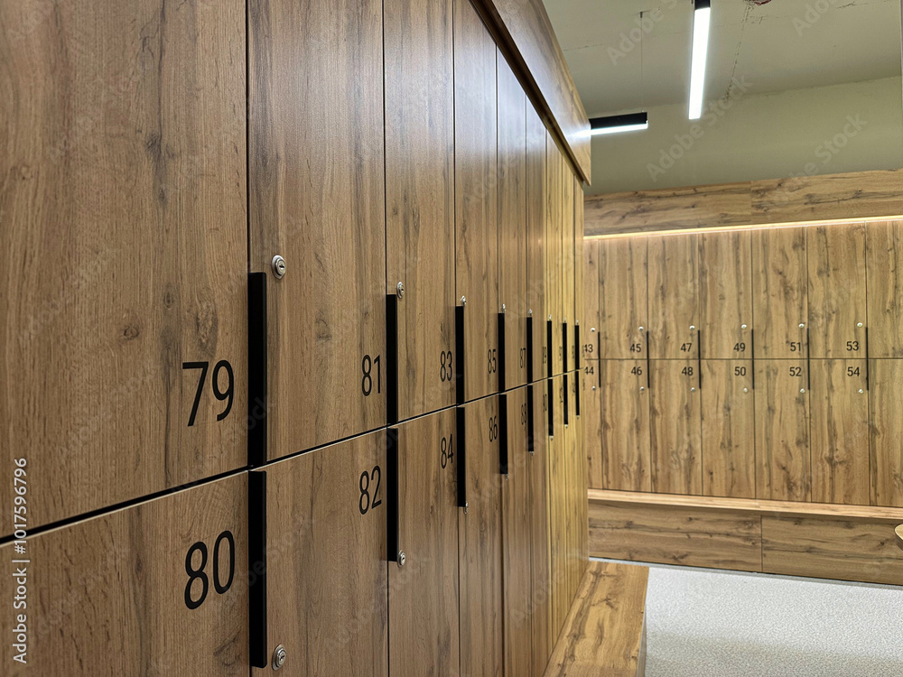 A locker room in a fitness center featuring wooden doors, each marked ...
