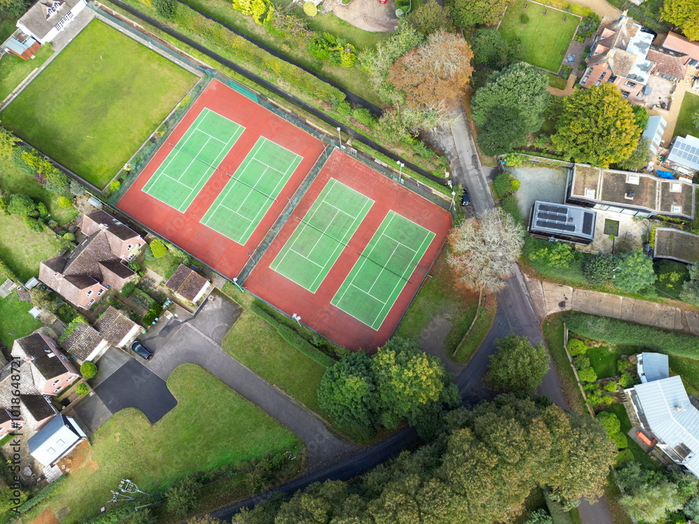 Four side by side public tennis courts seen in a typical British town ...