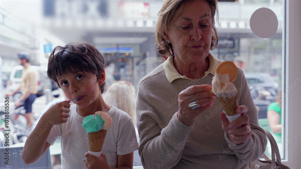 Young boy and his grandmother enjoying ice cream cones together in a ...