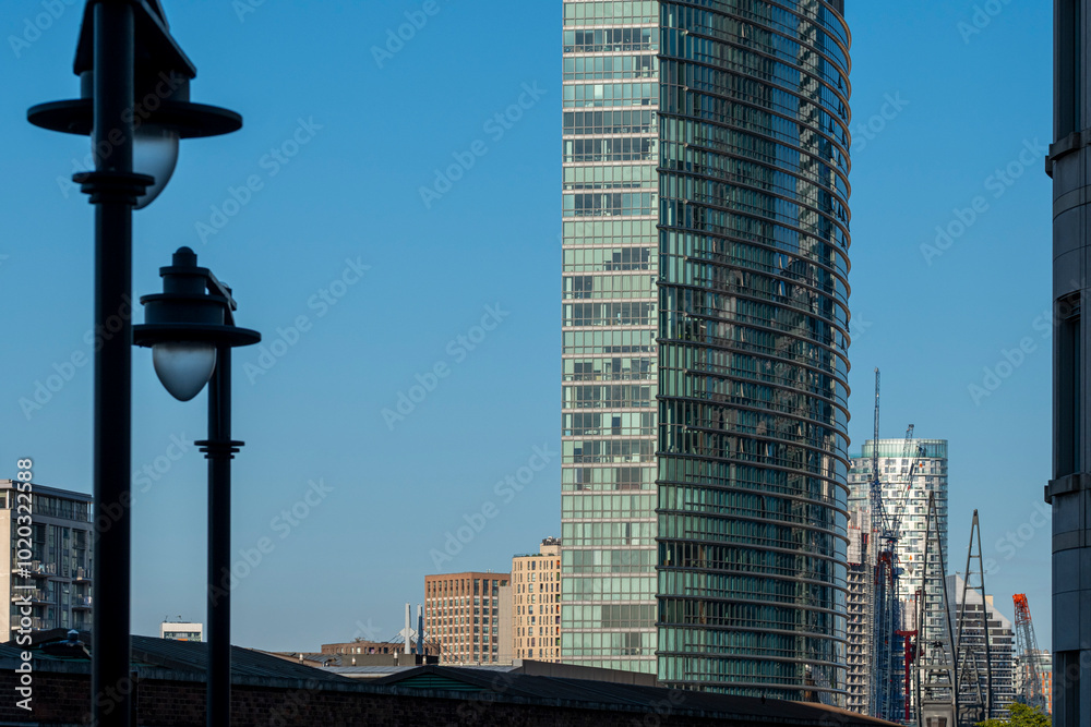 The image focuses on a tall skyscraper rising into a clear blue sky ...