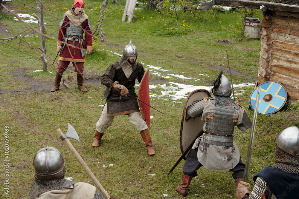 Medieval reenactment scene showing armored warriors wielding weapons ...