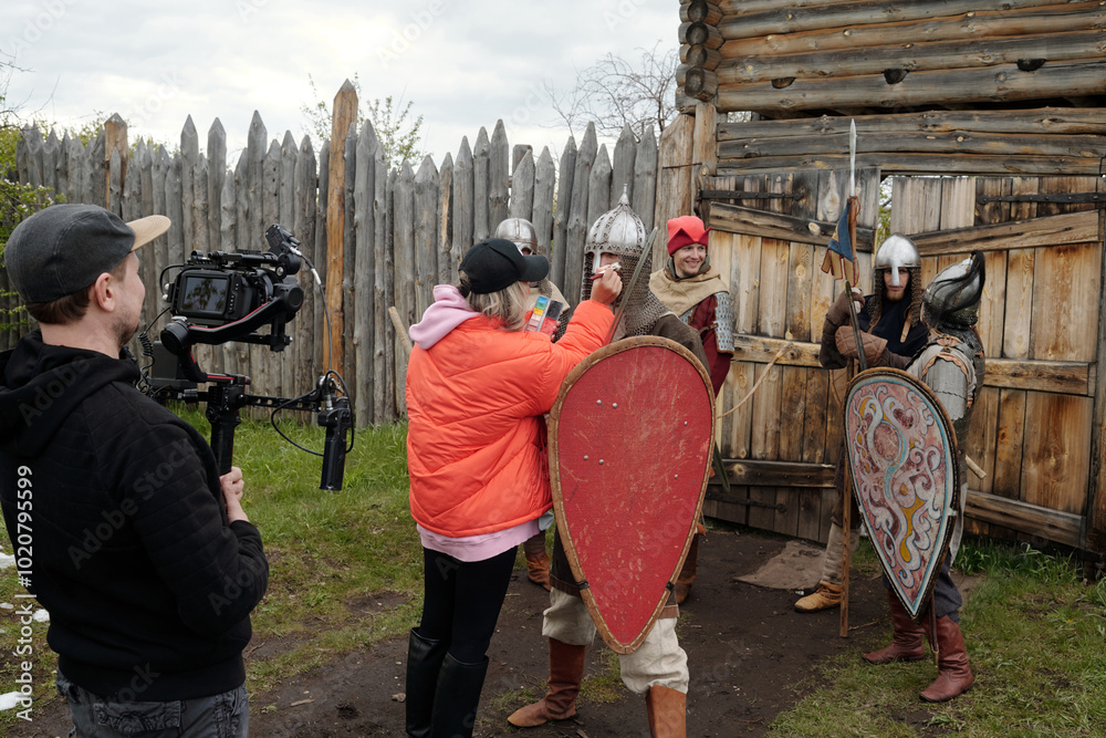 Crew preparing for medieval battle scene with actors dressed in armor ...