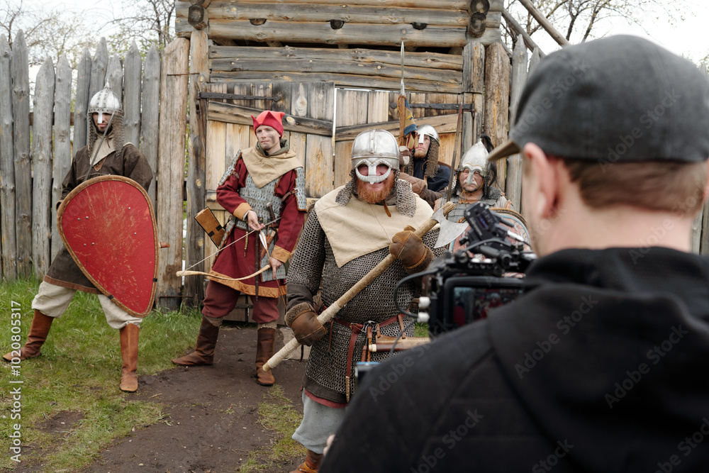Group of actors dressed in medieval armors standing outside wooden ...