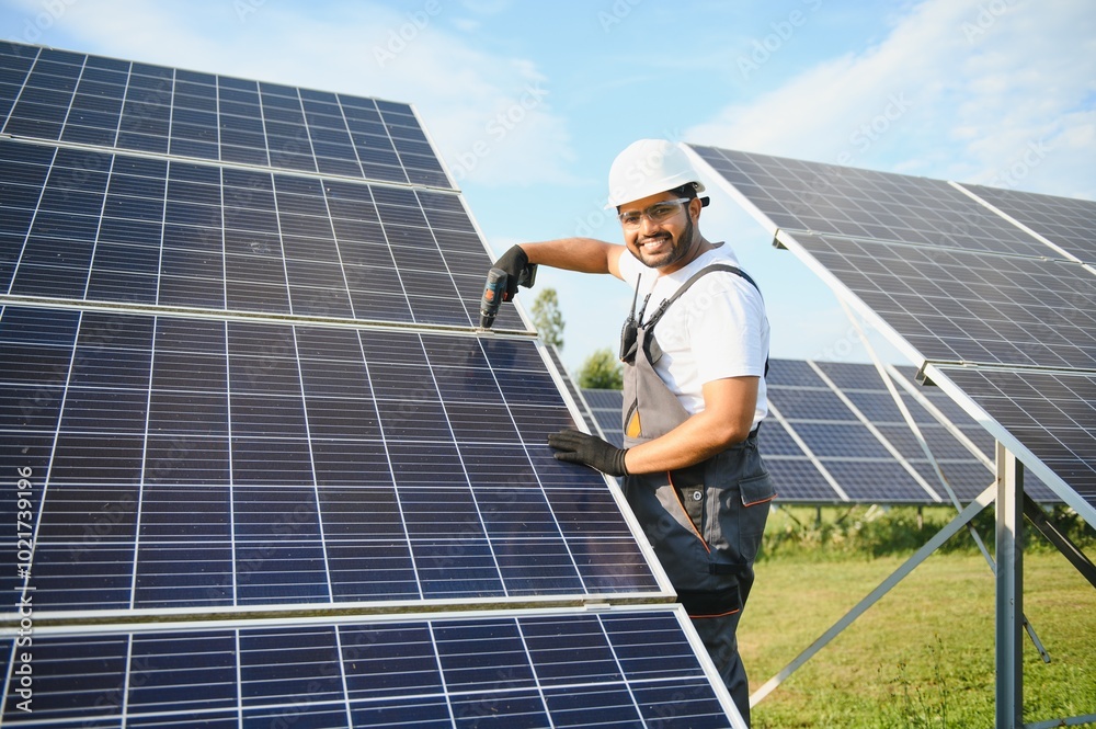 Indian man in uniform on solar farm. Competent energy engineer ...