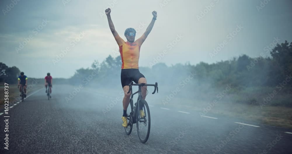 Cyclist Raises His Arms in Triumph While Crossing the Finish in Front ...