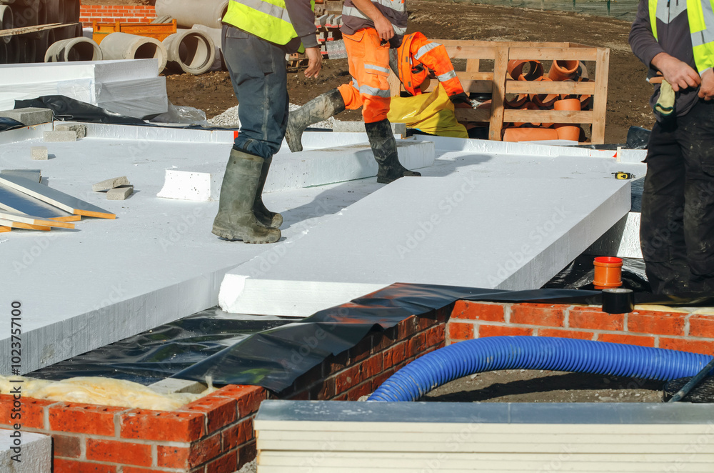 Construction workers on a building site laying underfloor Expanded ...