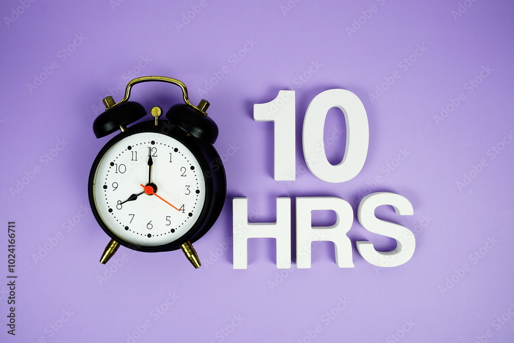 10 Hrs alphabet letters and alarm clock top view on purple background ...